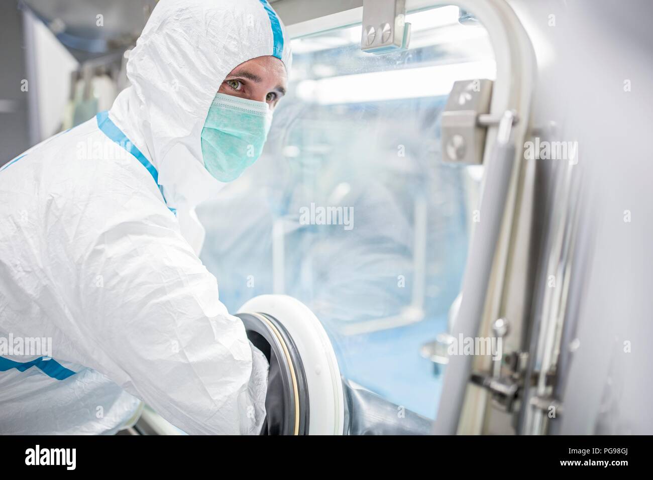 Technicians working in sealed, sterile isolator units in a laboratory ...