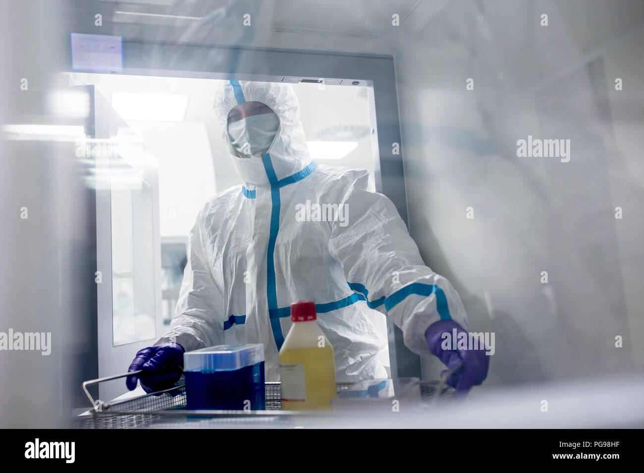 Technician collecting equipment from a transfer hatch in a sterile ...
