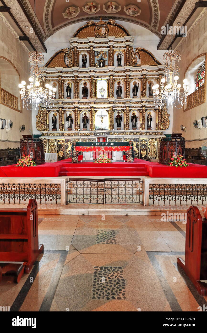 Church's gilded altarpiece with effigies of saints behind the main ...