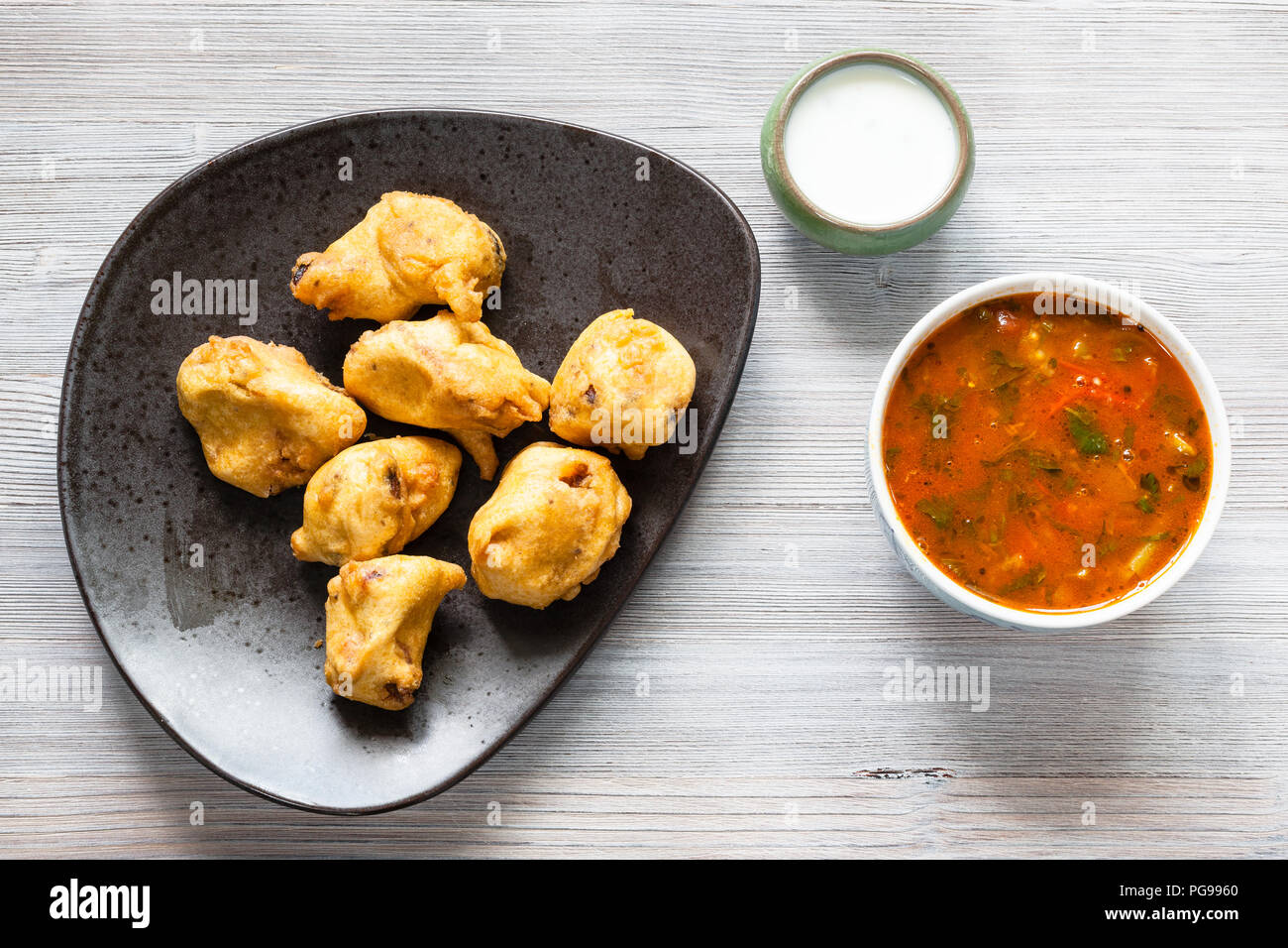 Indian cuisine - Chicken Pakoda pieces dipped in spiced butter on black ...