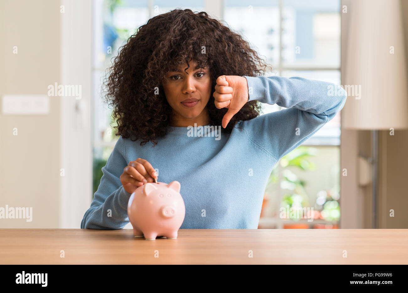 African american woman saves money in piggy bank with angry face ...