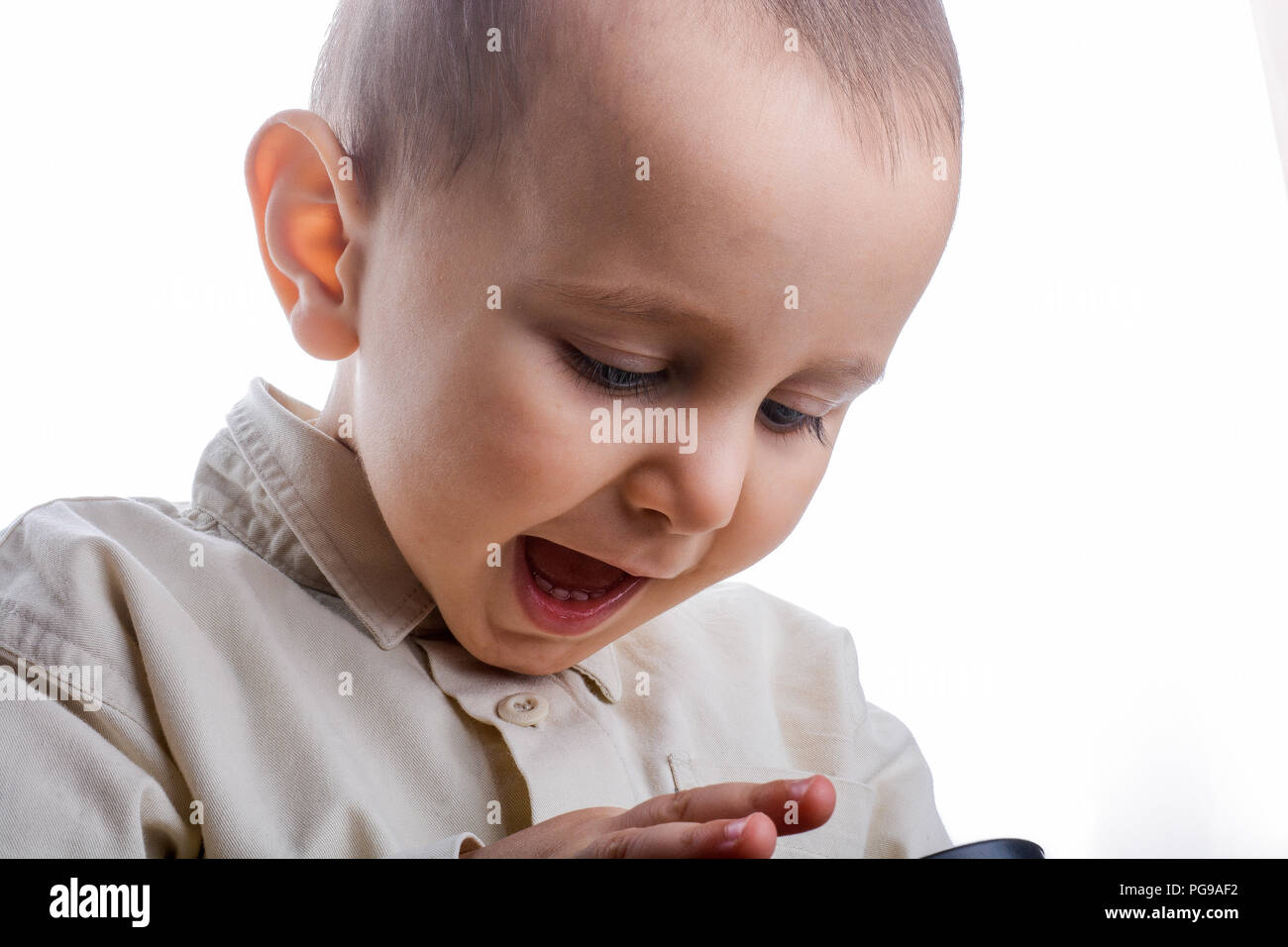 Baby holding a magnifying glass in hand on a white background Stock ...