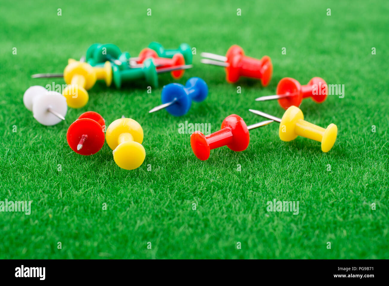 Colorful pins on green grass Stock Photo - Alamy