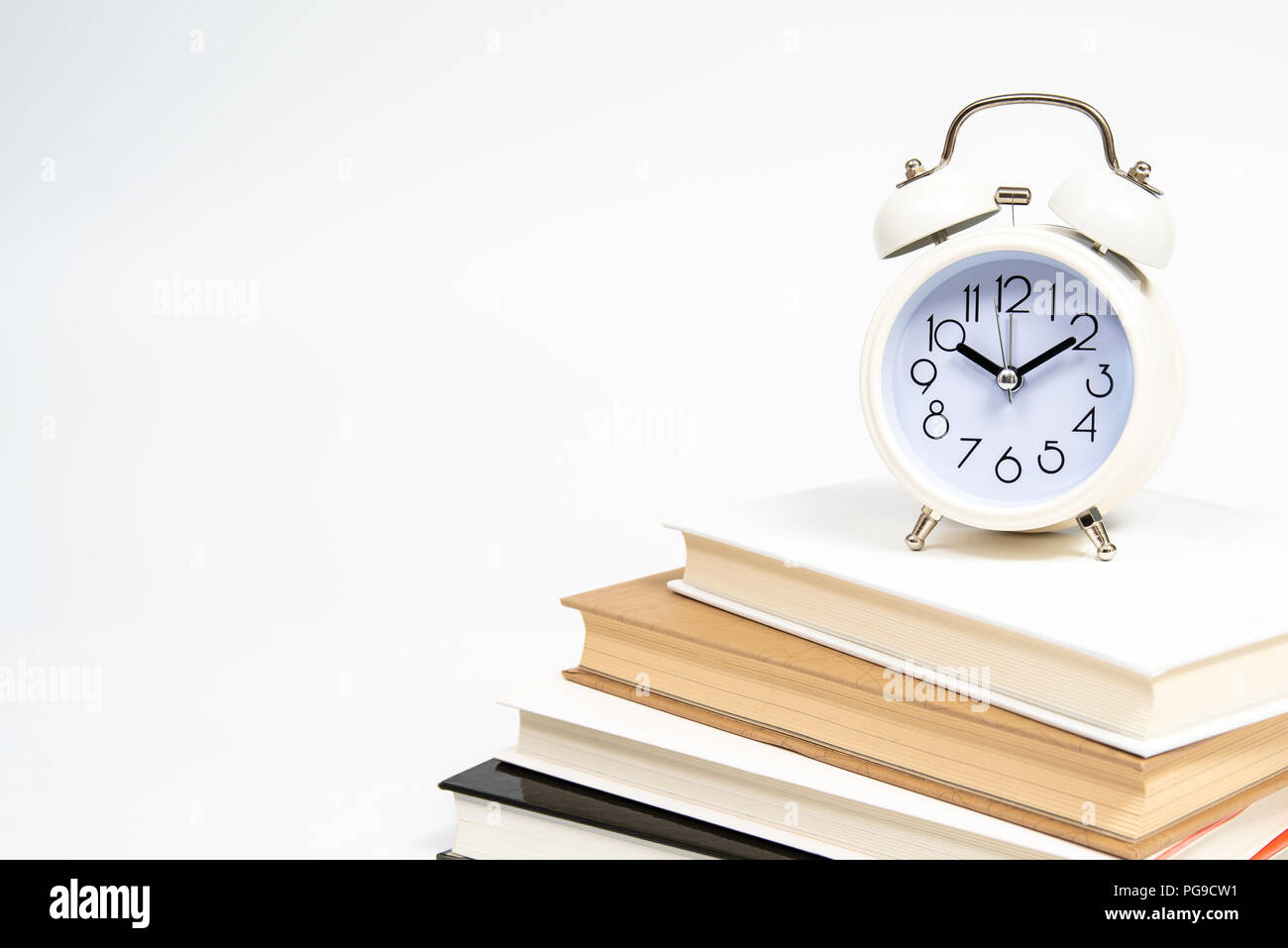 Alarm clock and books isolated on white background Stock Photo - Alamy