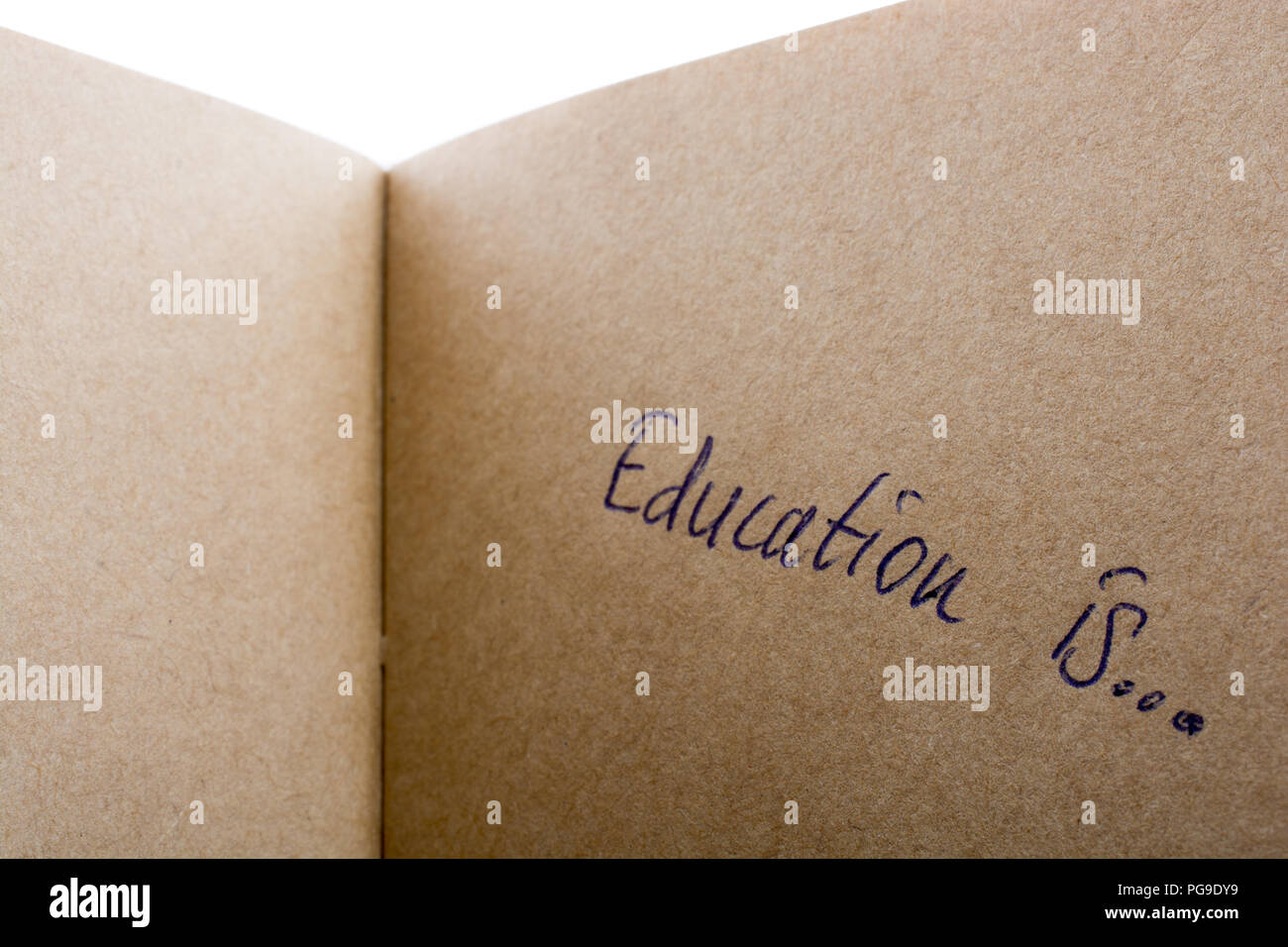'Education is...' written on a notebook Stock Photo - Alamy