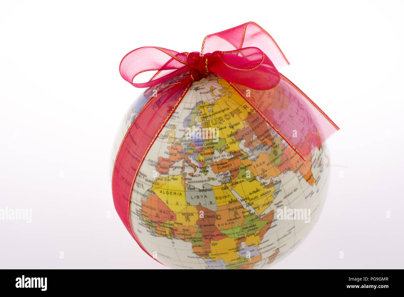 Globe tied with red ribbon on a white background Stock Photo - Alamy
