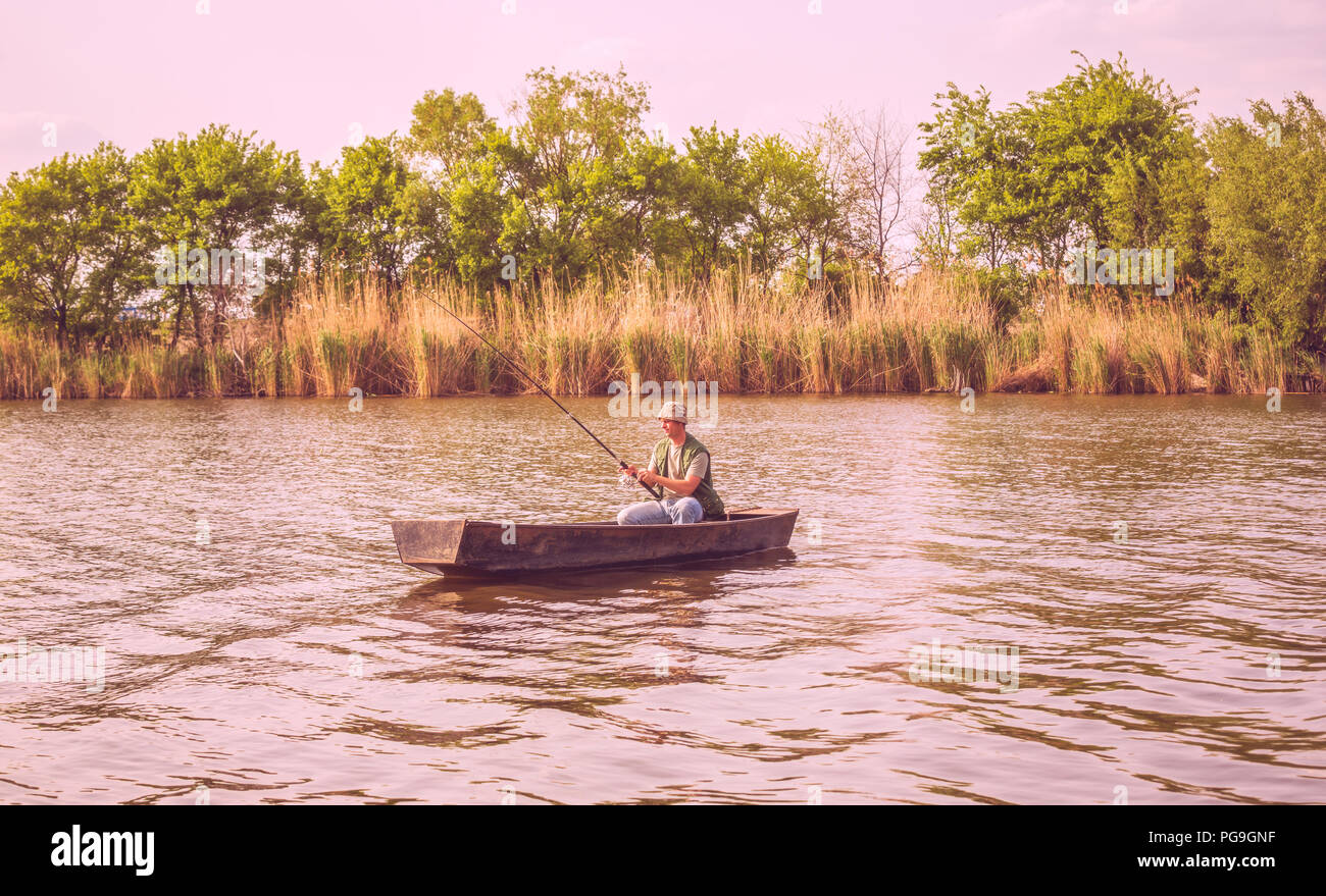 Fisherman catches a fish. - young man fishing on river Stock Photo - Alamy