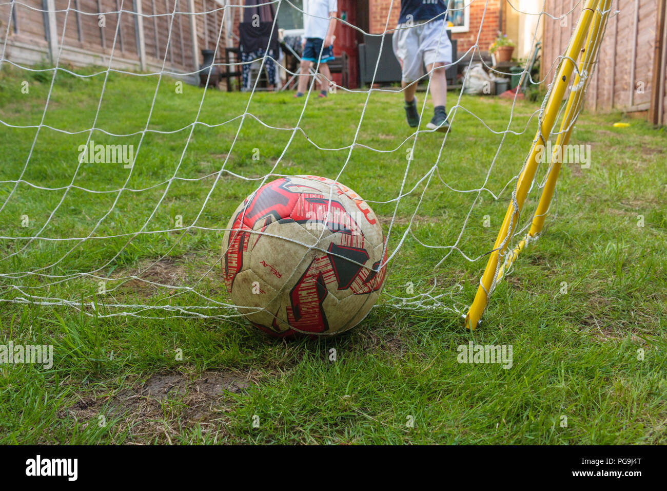 A football in the back of a goal in a back garden Stock Photo - Alamy