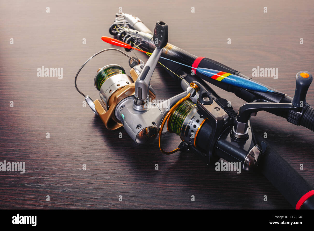 fishing rod with a coil on wooden background Stock Photo - Alamy