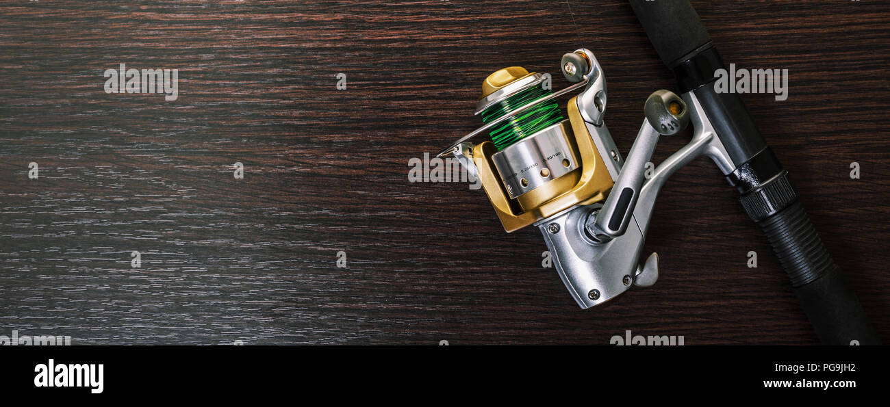 coil for fishing rod close-up on a wooden background Stock Photo - Alamy