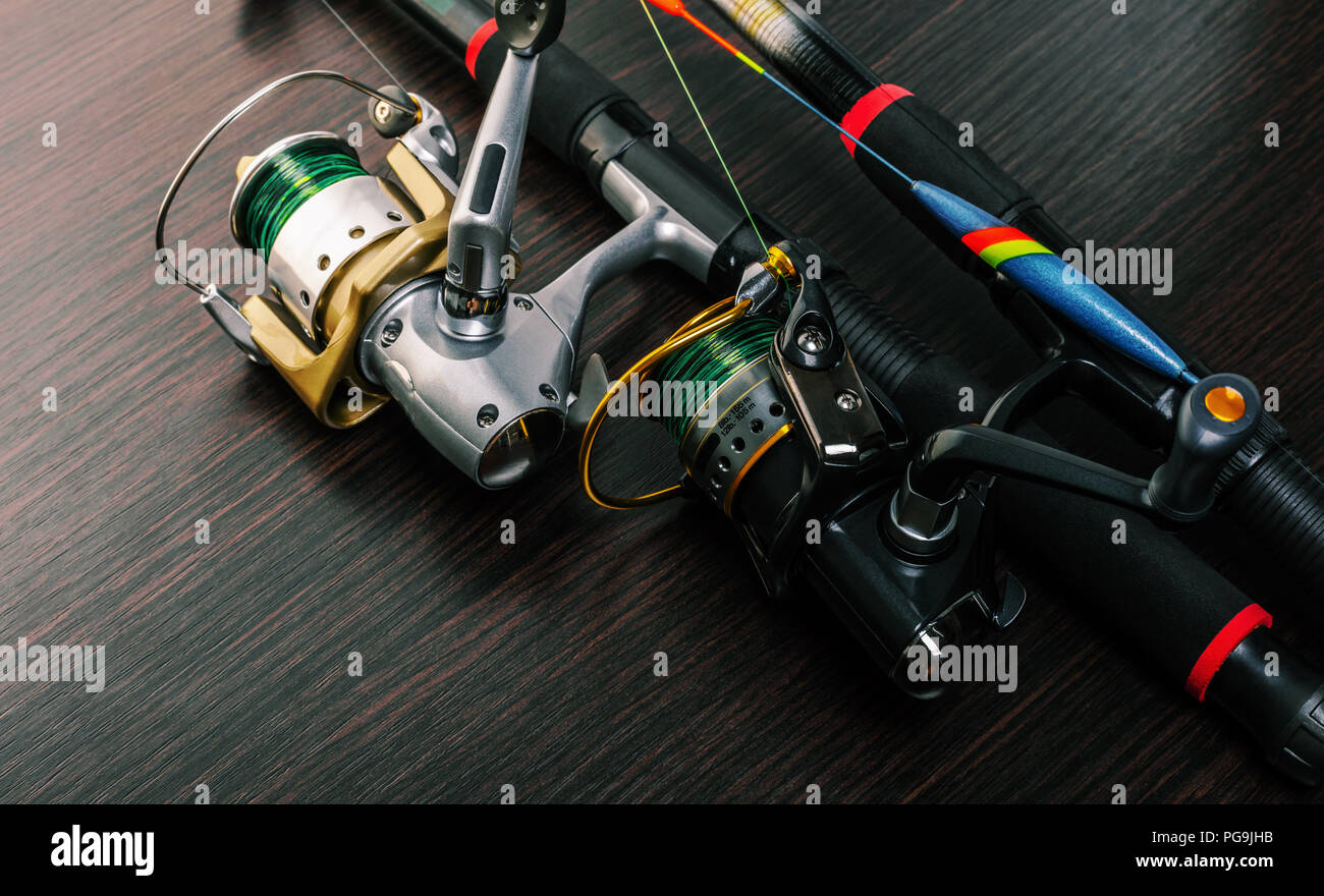 fishing rod with a coil on wooden background Stock Photo - Alamy
