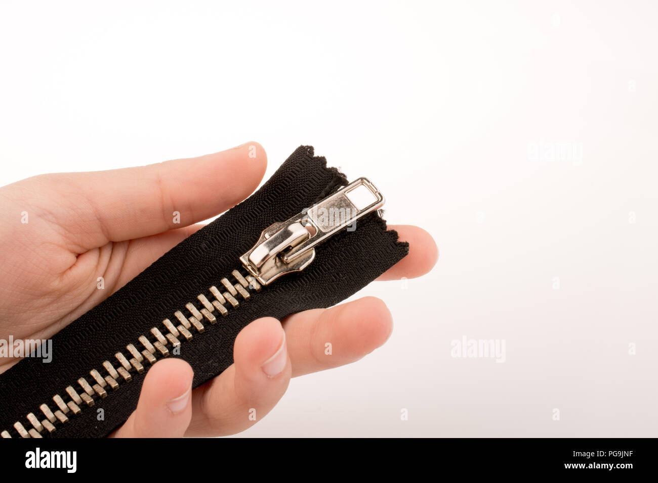Hand holding color zipper on a white background Stock Photo - Alamy