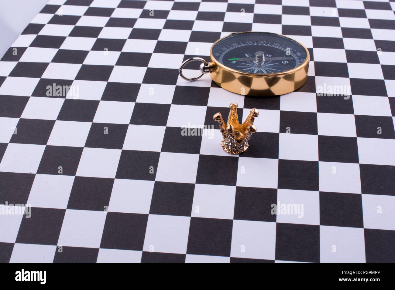 Retro Compass with a crown on a checked background Stock Photo - Alamy