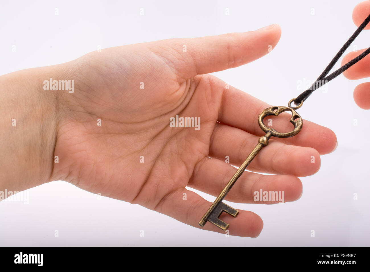 Hand holding a key on a white background Stock Photo - Alamy