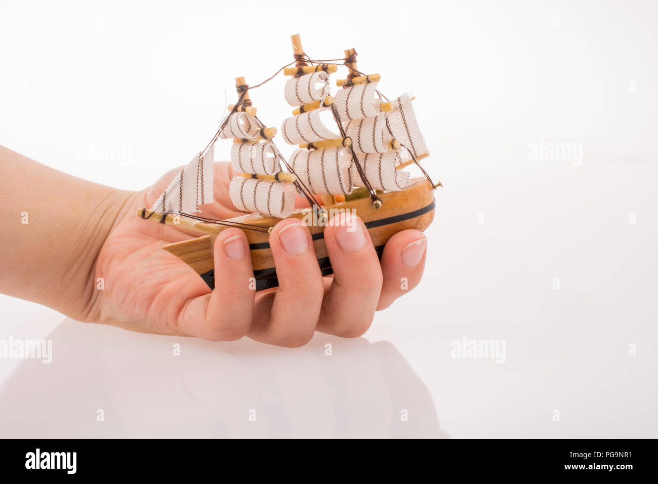 Hand holding a Little model sailboat on a white background Stock Photo ...