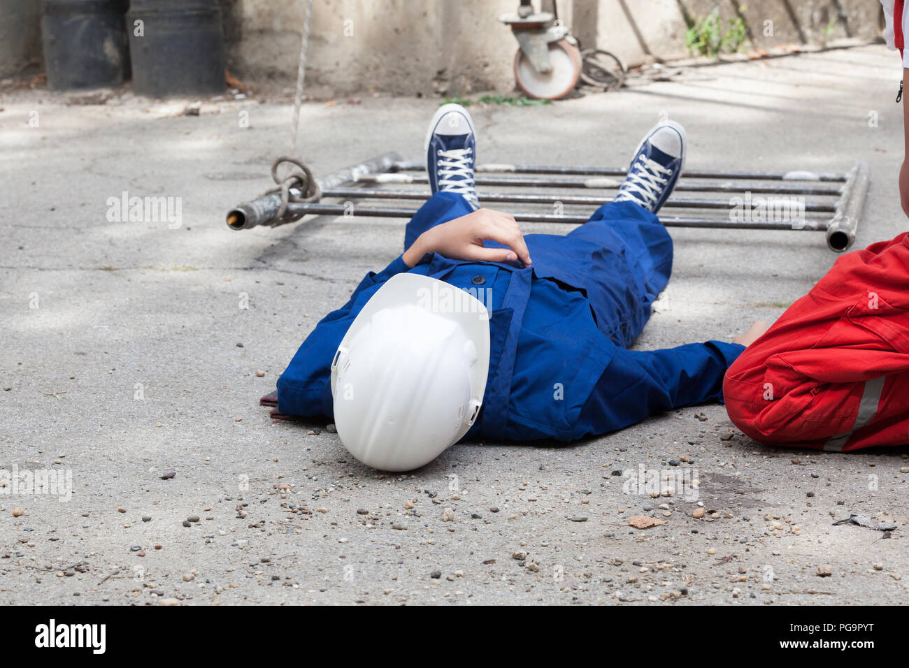 Paramedics helping a worker after the fall at a construction site ...