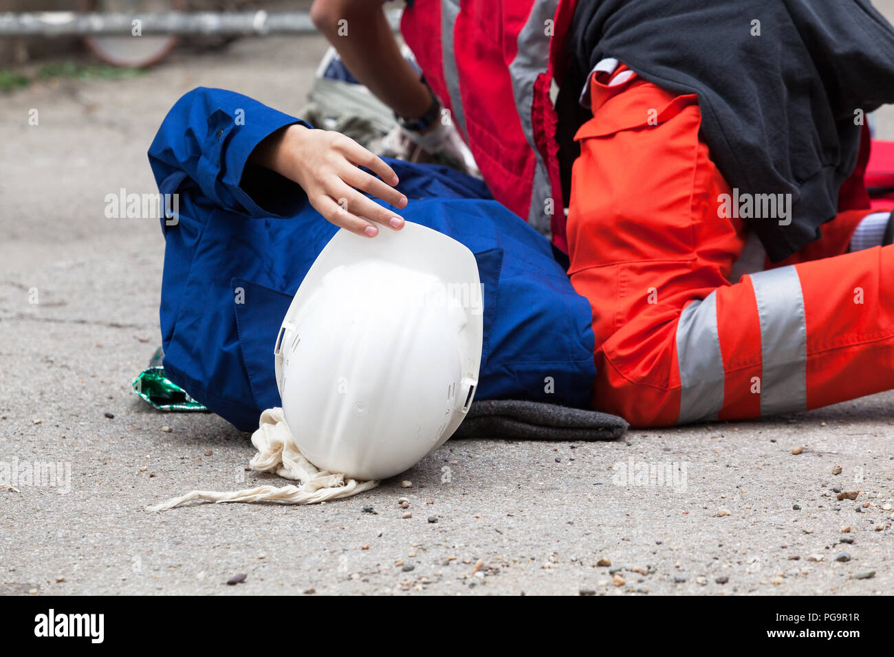 Paramedics helping a worker after the fall at a construction site ...