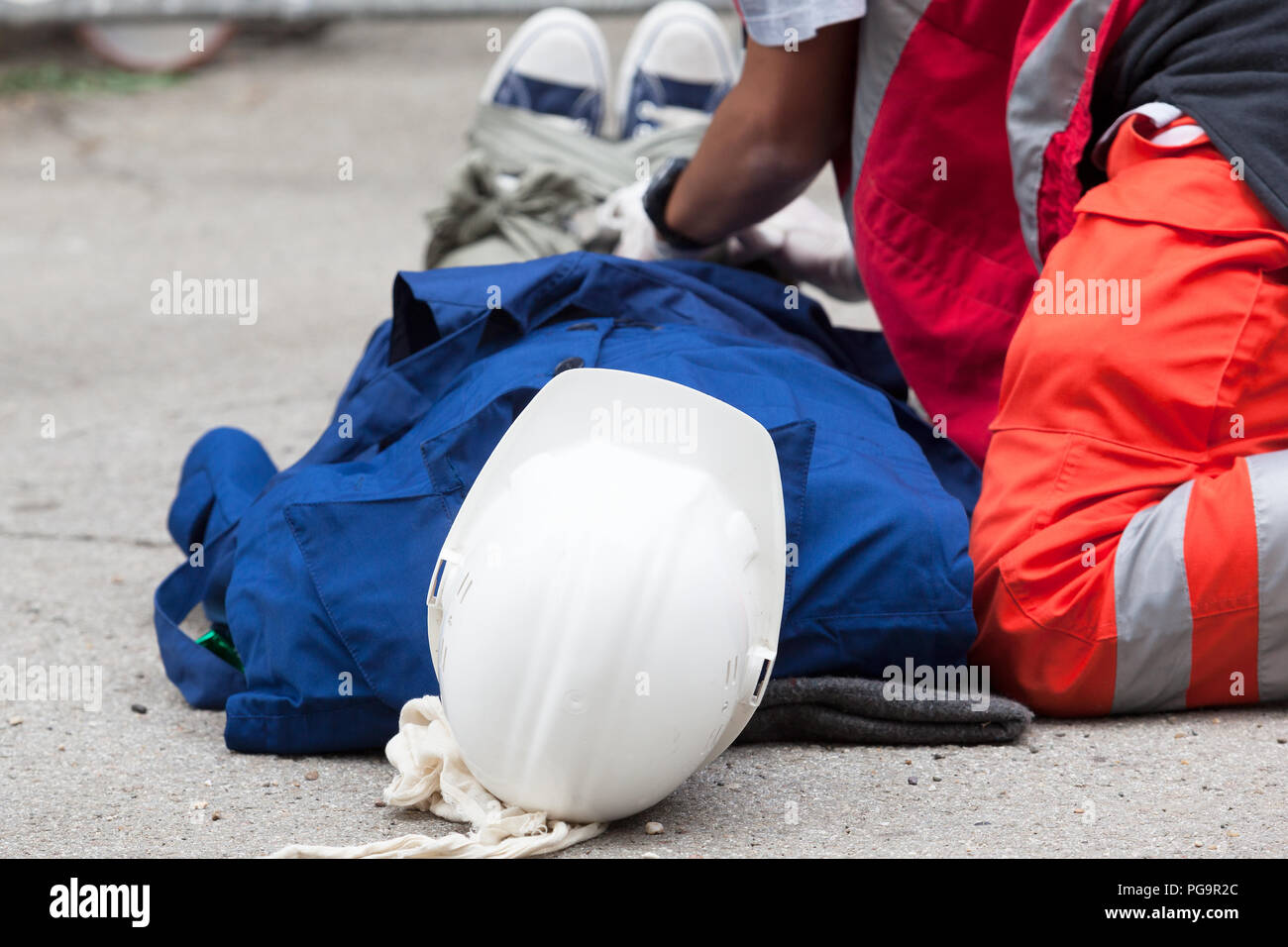 Paramedics helping a worker after the fall at a construction site ...