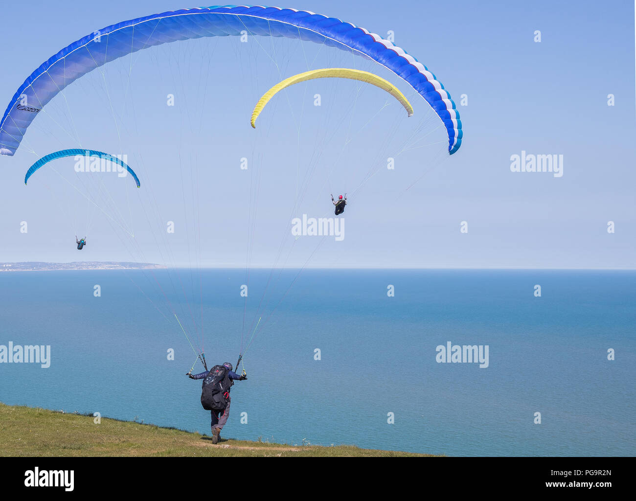 Paragliding man taking off from edge of cliff Stock Photo - Alamy