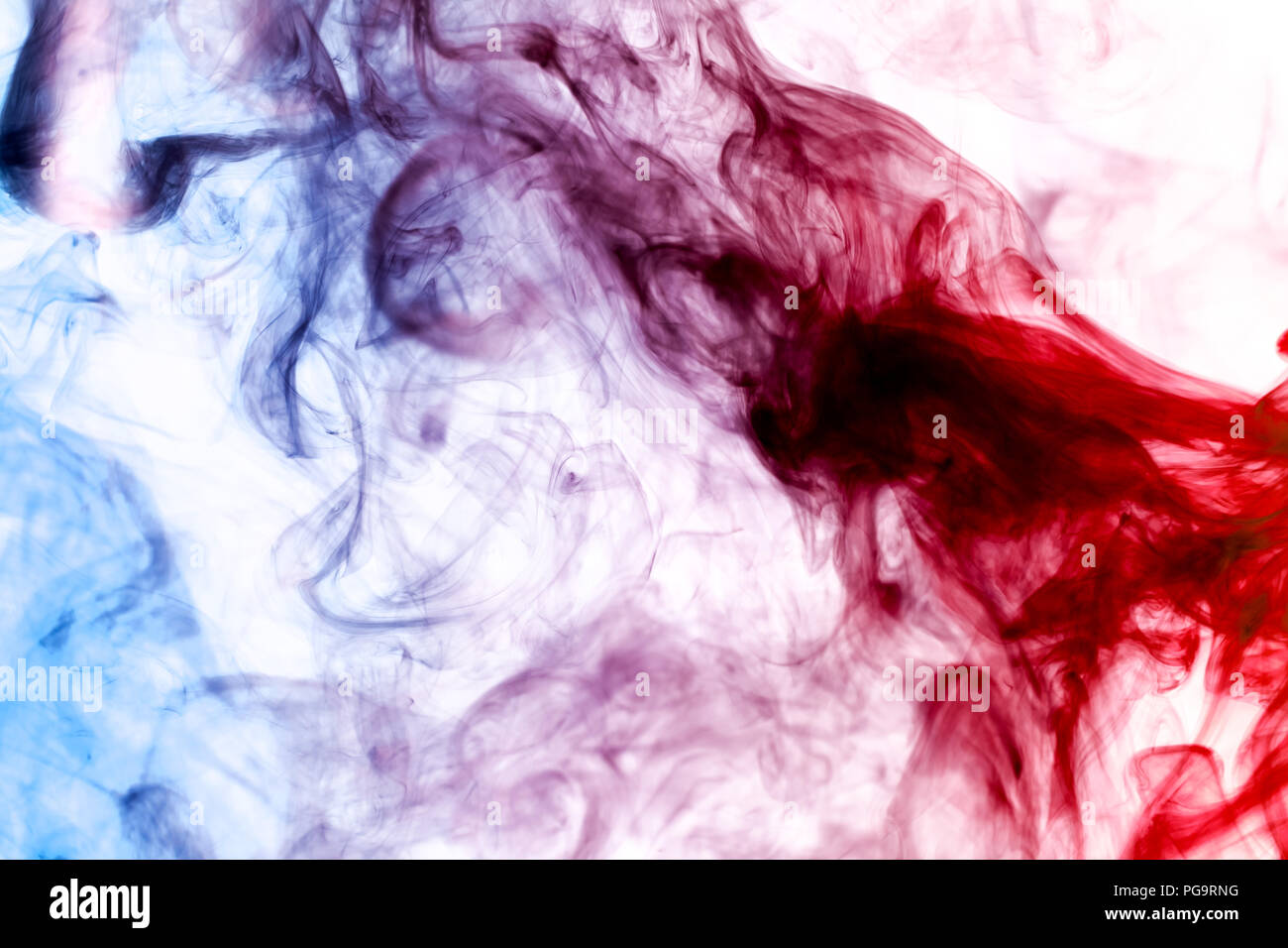 Dense multicolored smoke of blue and red colors on a black isolated ...