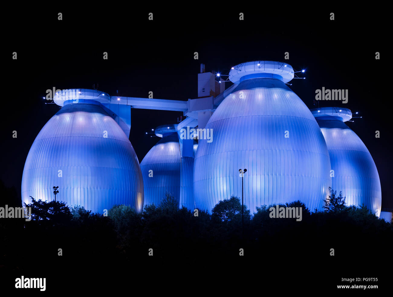 A sewage plant with blue illumination at night, looking surreal like an ...