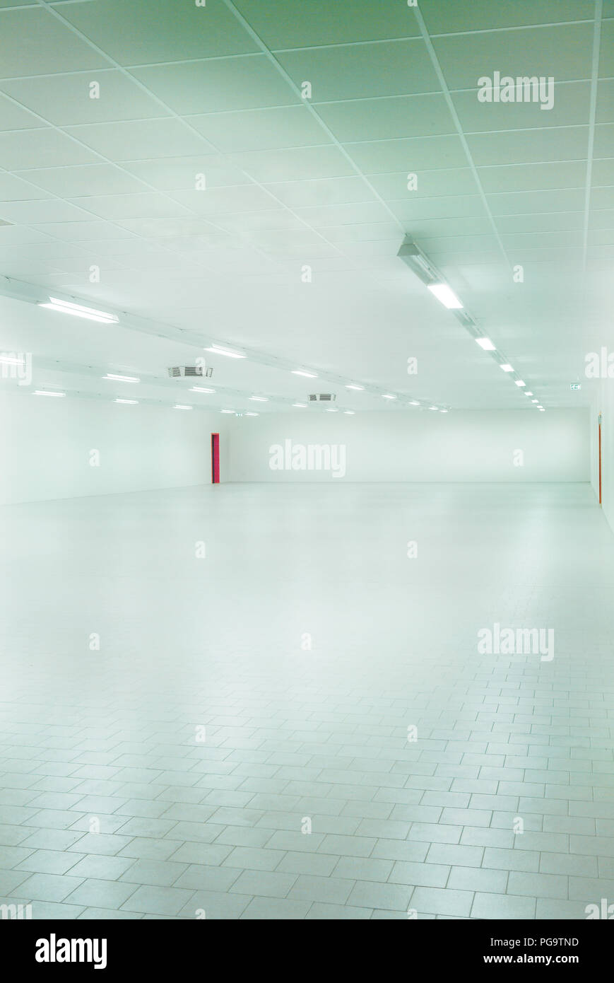 A white empty hall with an red door Stock Photo - Alamy