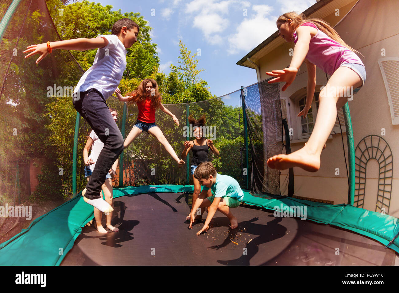 Happy friends jumping on the trampoline in summer Stock Photo - Alamy