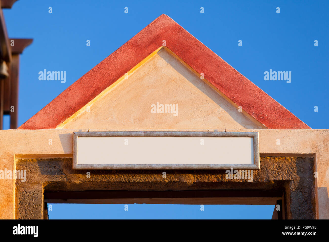 An empty sign hanging in front of an entrance with an arch Stock Photo ...