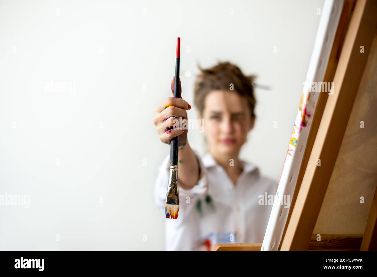 Woman artist holding paintbrush Stock Photo - Alamy