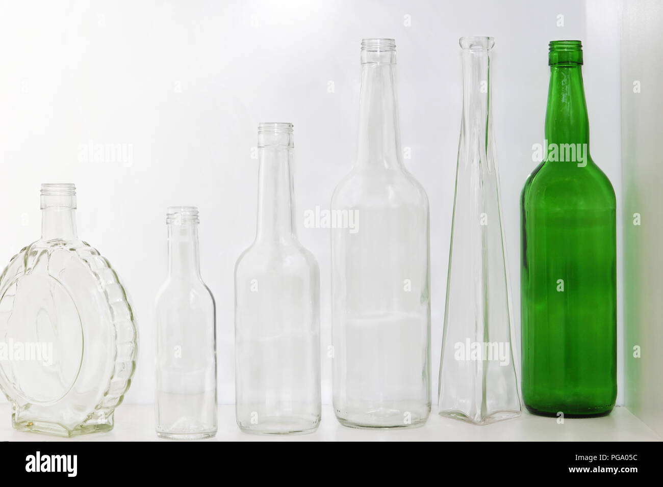 Various shape glass bottles at shelf Stock Photo - Alamy