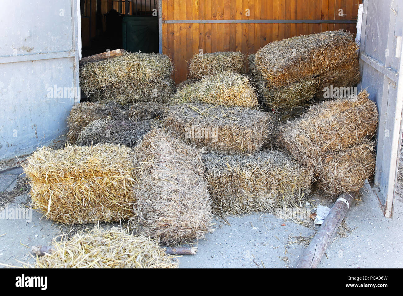 Square bale hay in front of stables Stock Photo - Alamy