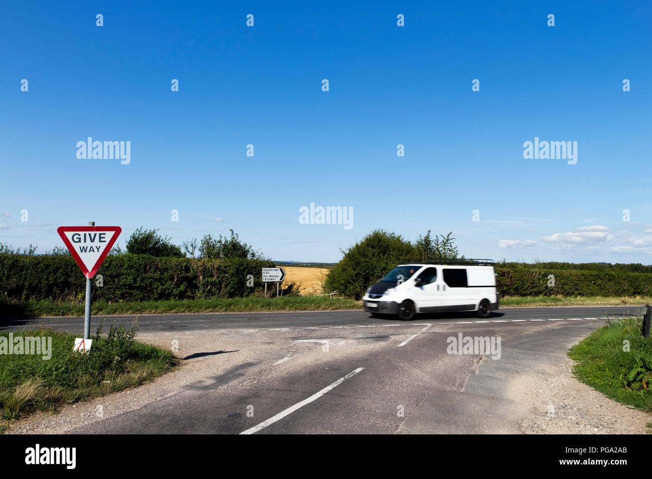 give way road sign on country lane joining main highway junction in ...