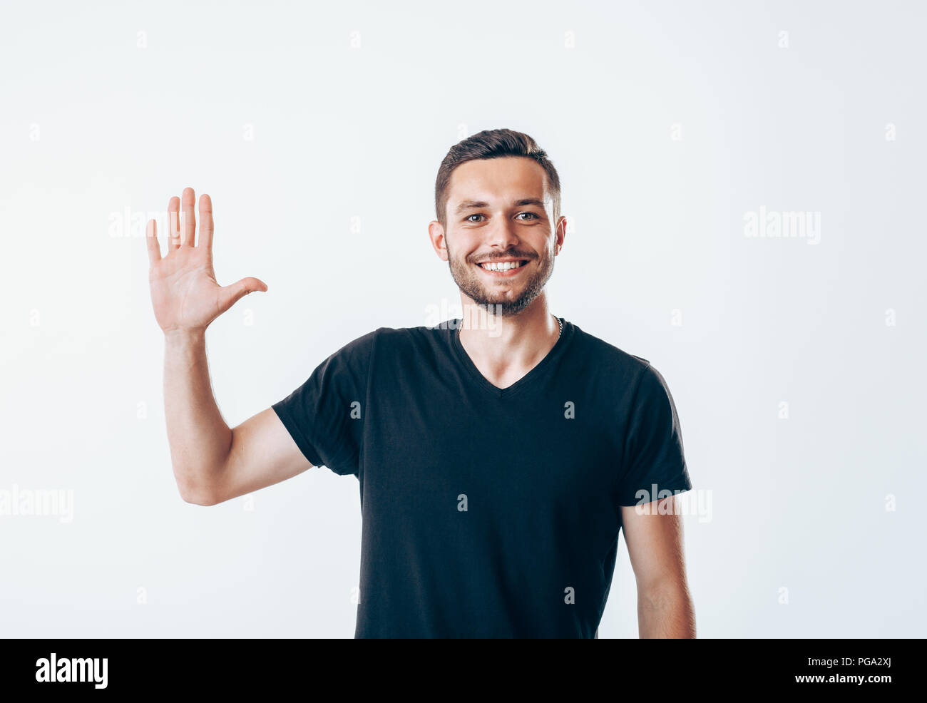 Portrait of smiling man with hand raised in greeting. High five concept ...