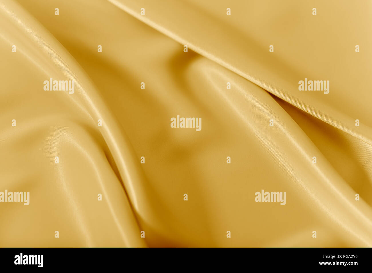 Smooth elegant shiny gold silk or satin luxury cloth texture can use as ...