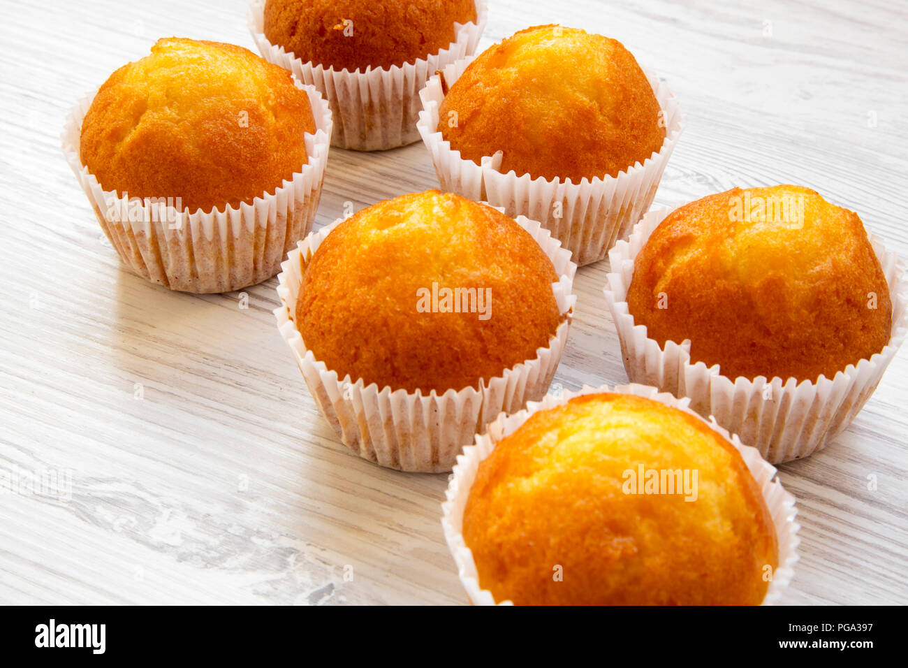 Fresh muffins on a white wooden table, side view. Close-up Stock Photo ...
