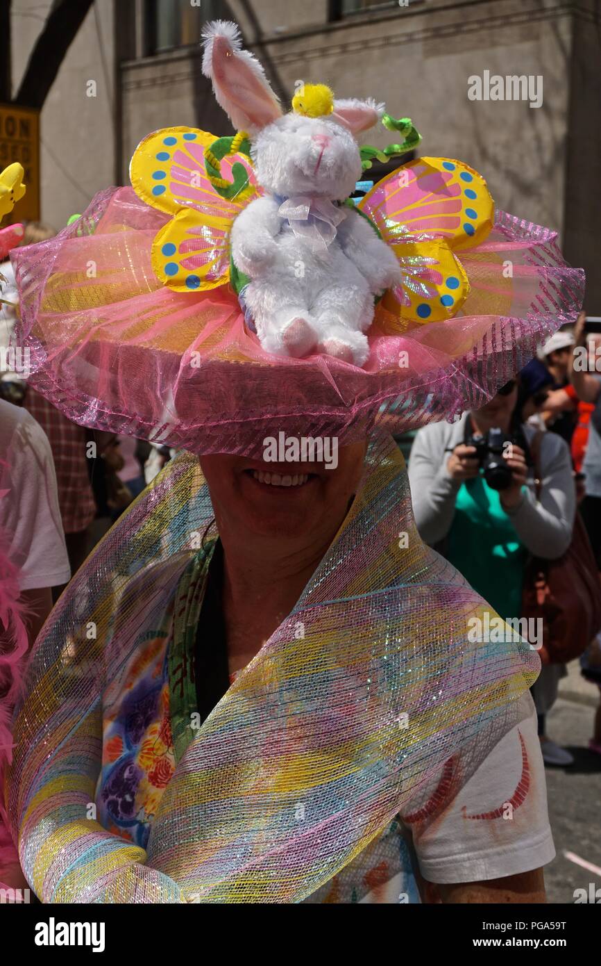 A smiling woman wears an elaborate Easter bonnet, complete with a ...