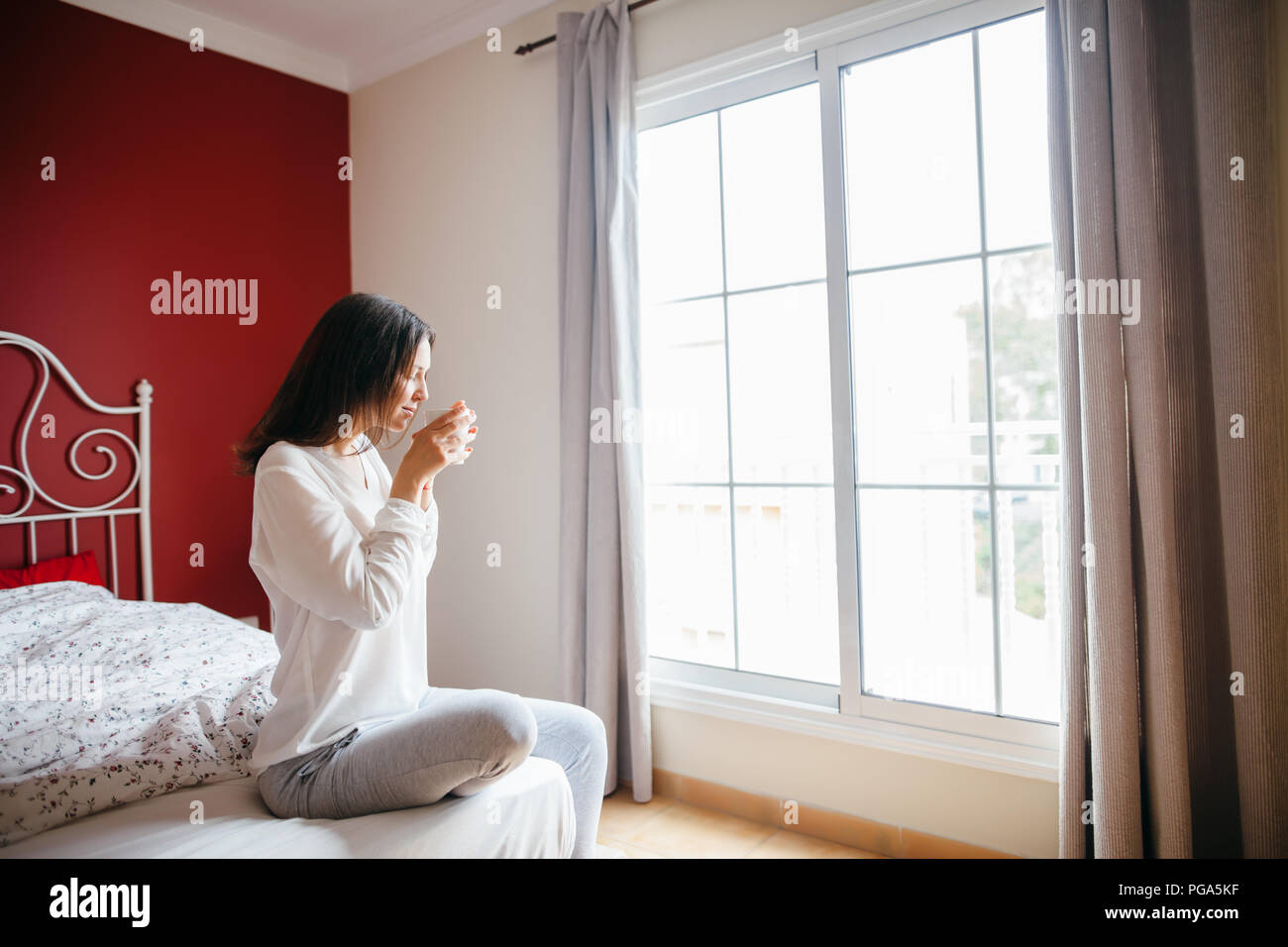Beautiful girl in bed drinking coffee in morning. Breakfast in bed ...