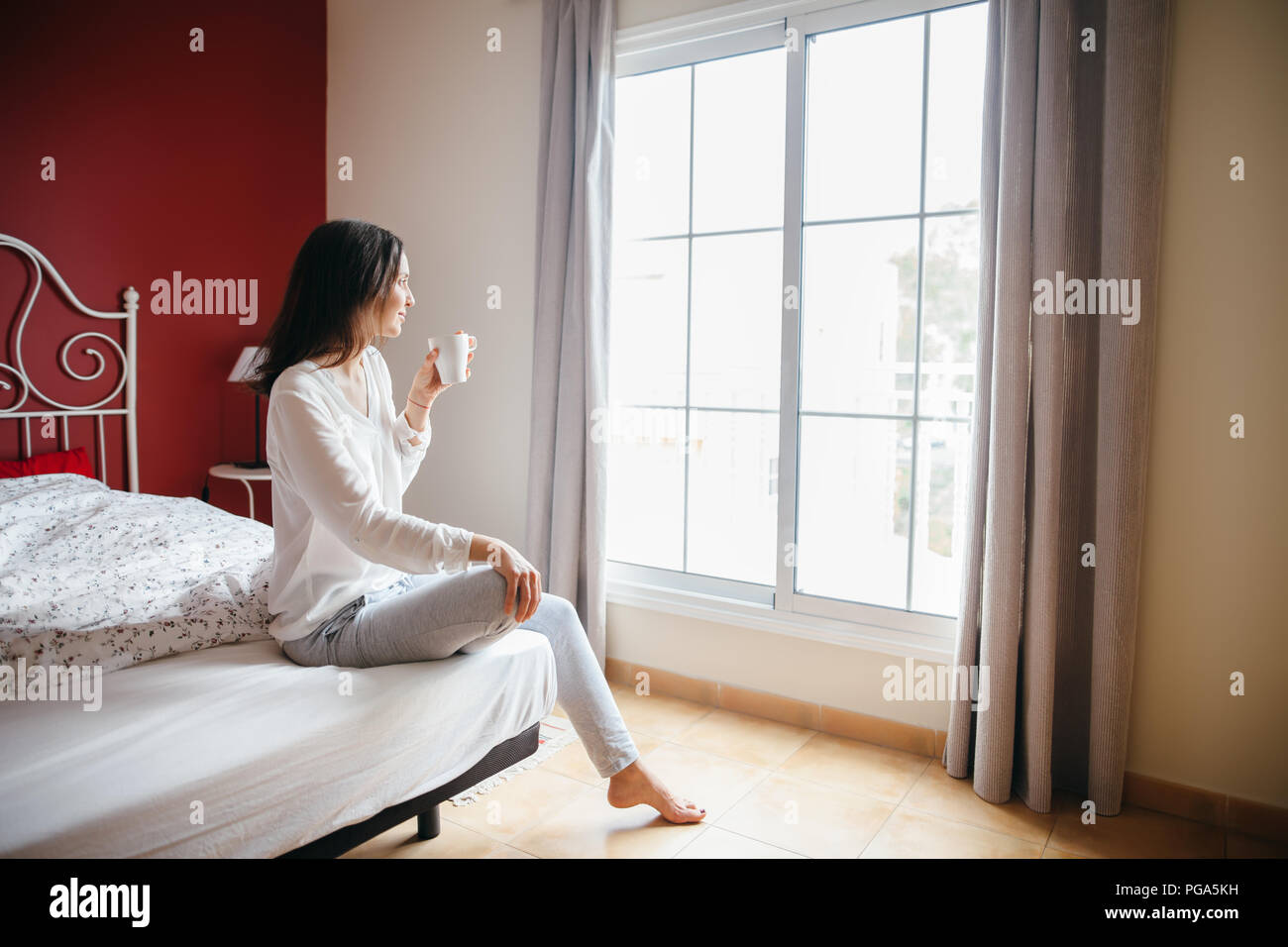 Beautiful girl in bed drinking coffee in morning. Breakfast in bed ...