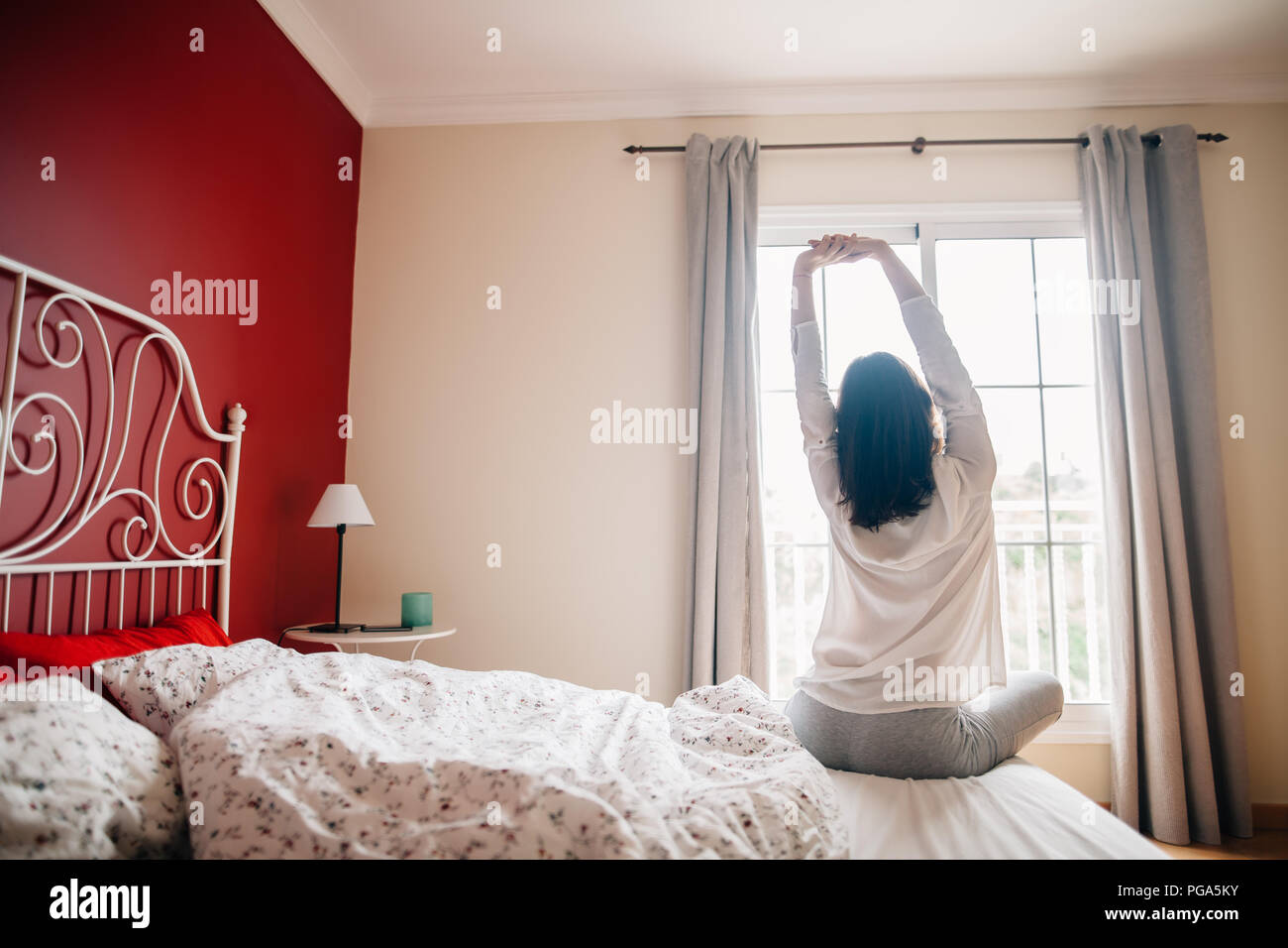 Pretty woman stretching in bed after wake up, back view Stock Photo - Alamy