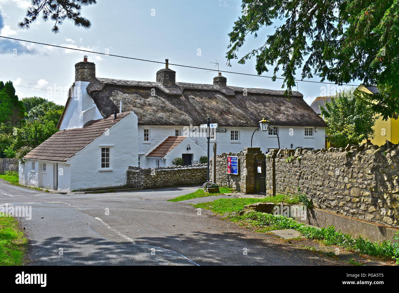 This pretty old thatched house is opposite the church in Colwinston, a ...