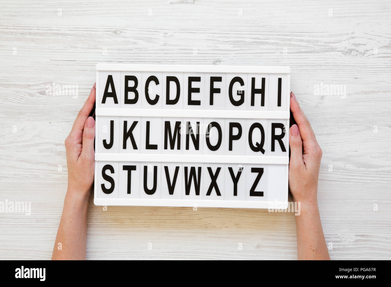 Female hands hold modern board with english alphabet on lightbox over ...