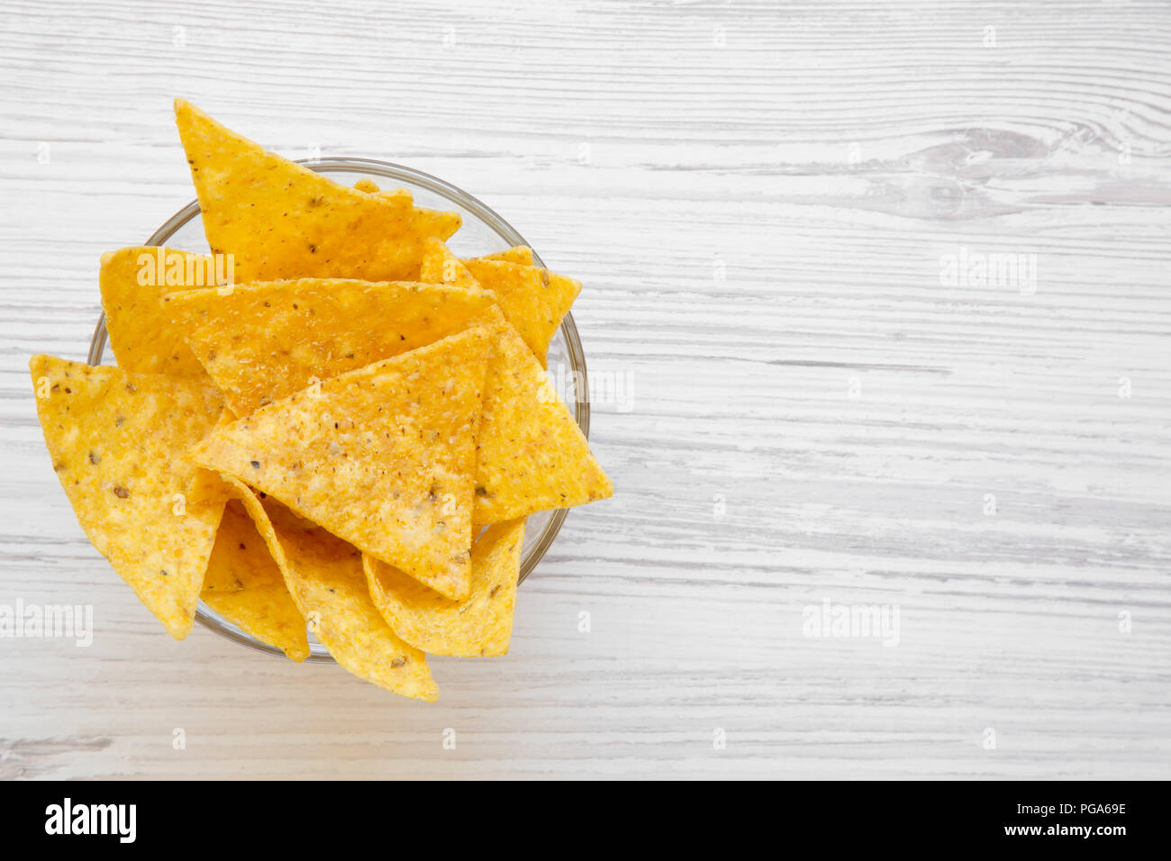 Full bowl of tortilla chips on white wooden background, top view ...