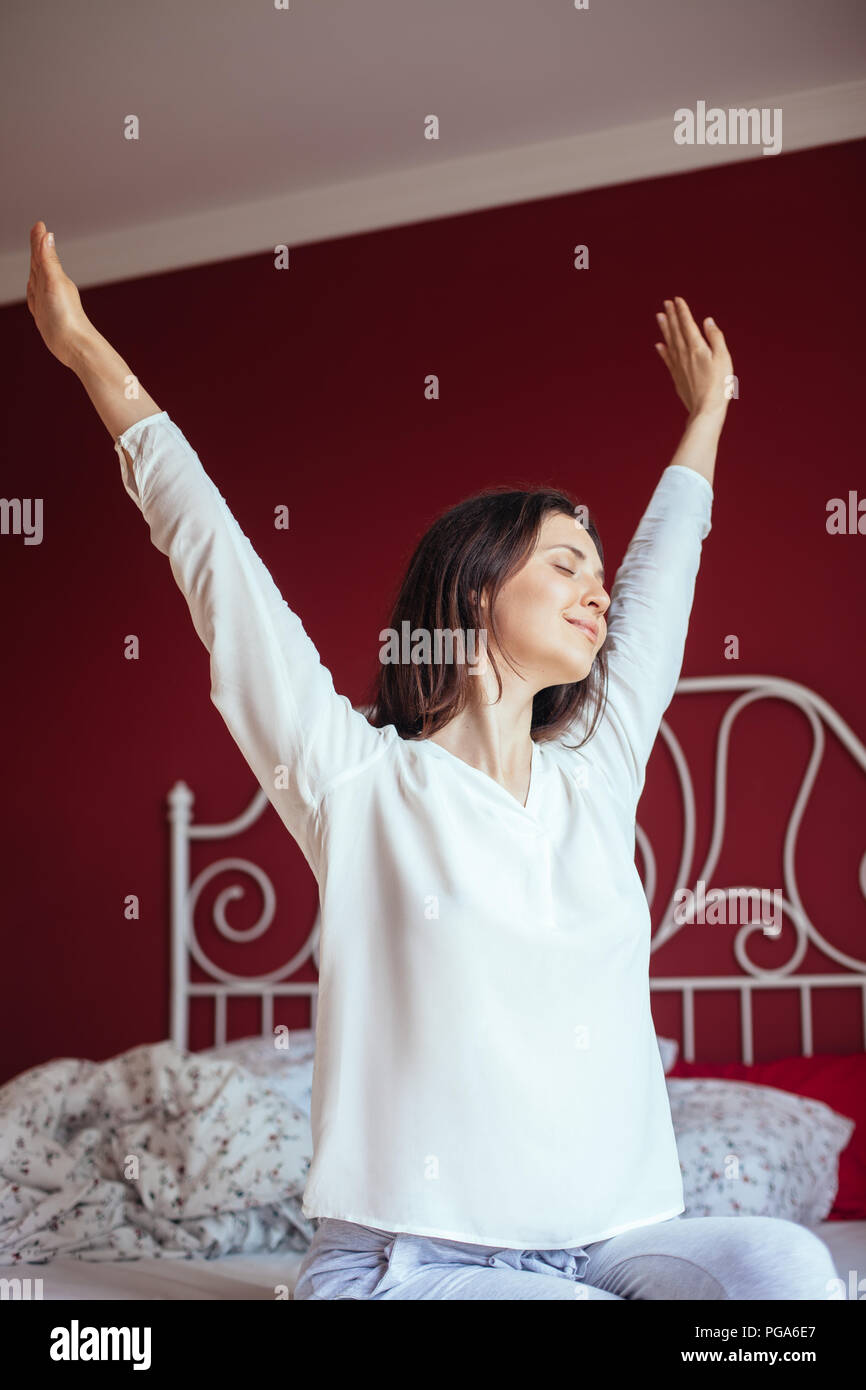 Portrait of pretty woman stretching in bed after wake up. Good morning ...