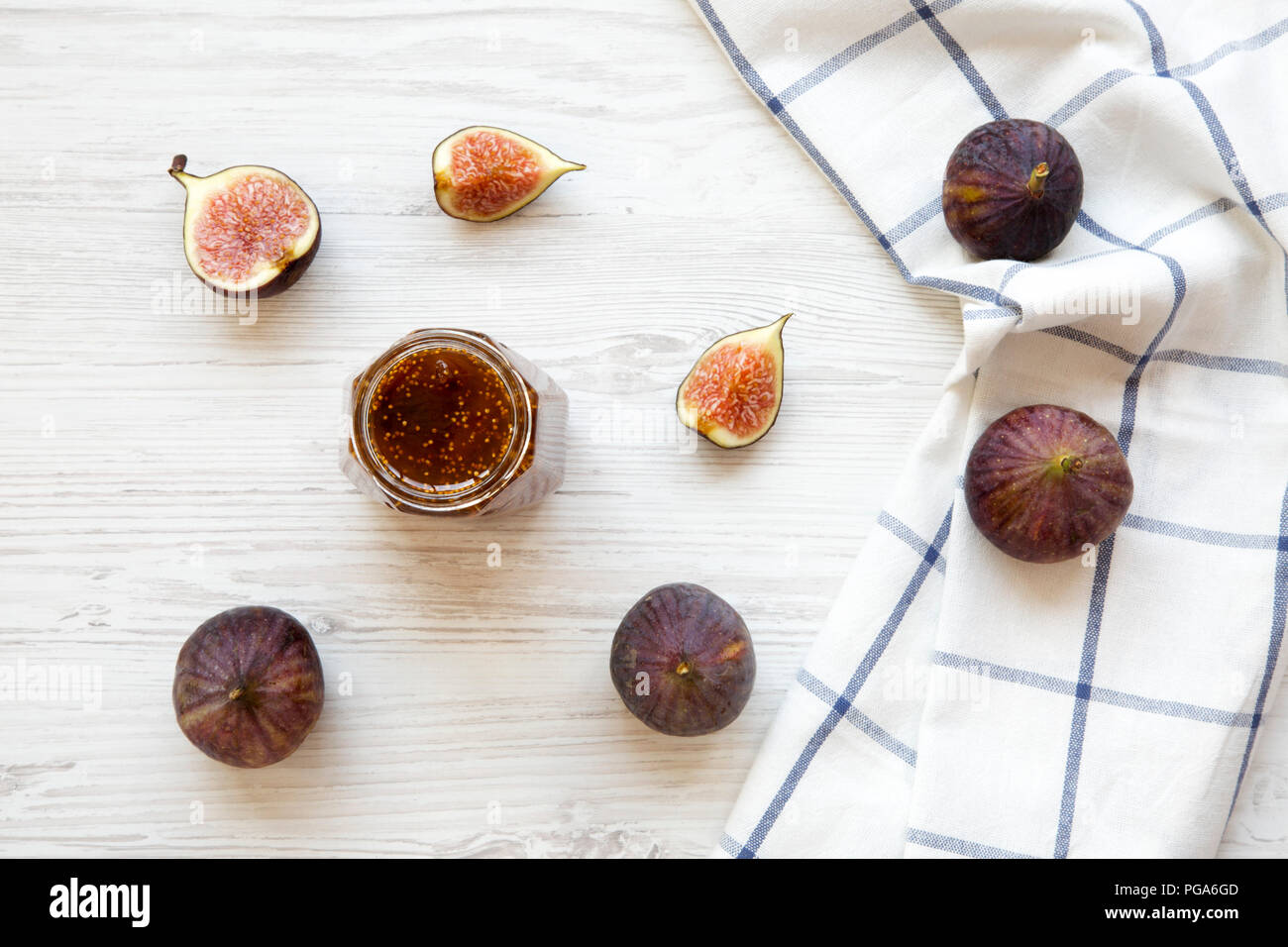 Fig jam in glass jar and fresh figs on white wooden background, top ...
