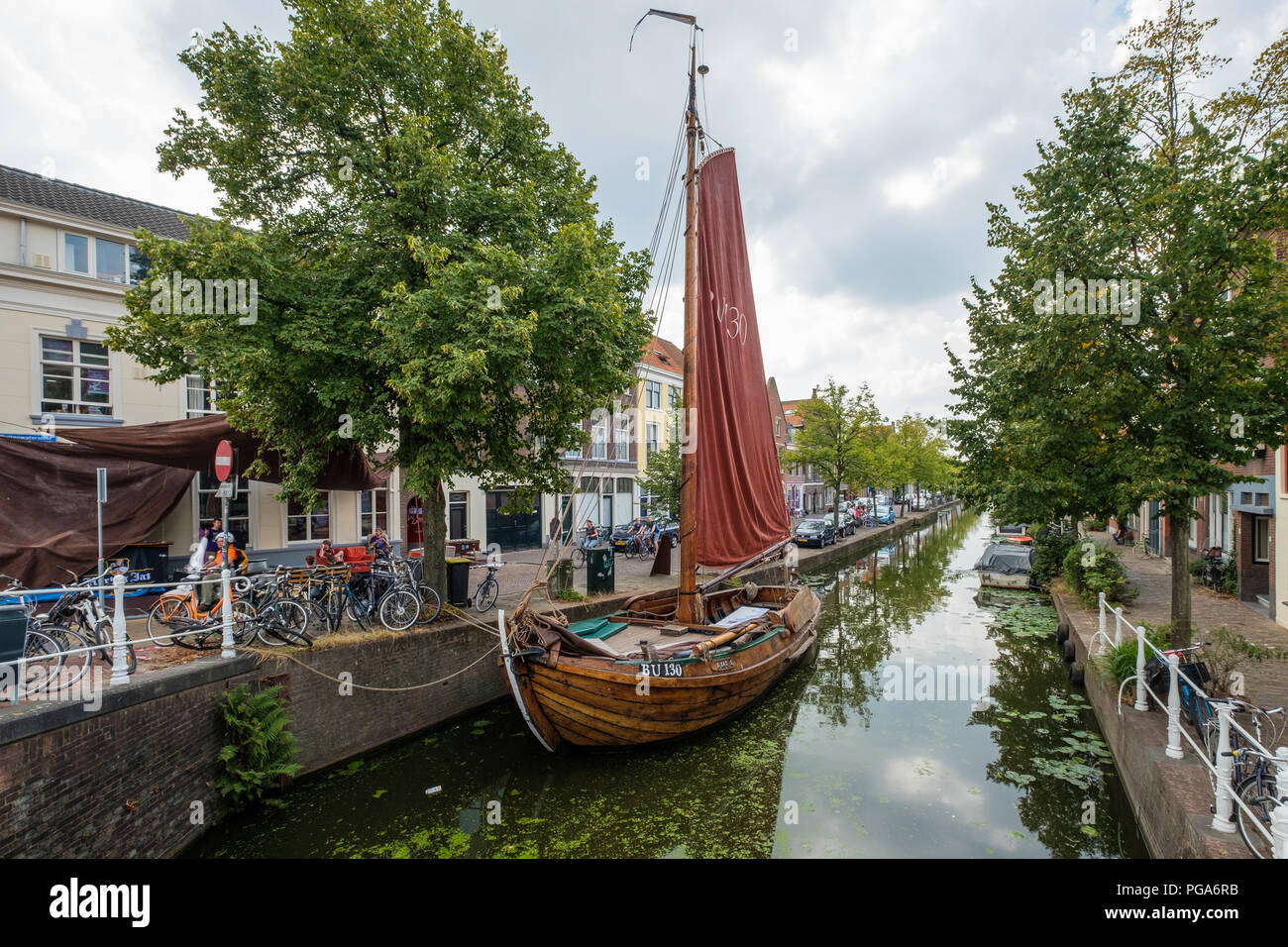 An old authentic fisher boat in a canal in the city center of Delft ...