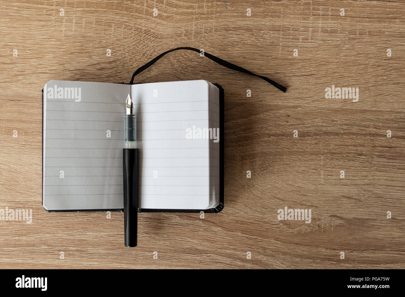 Fountain pen on a notebook. Wooden table. Copy space Stock Photo - Alamy