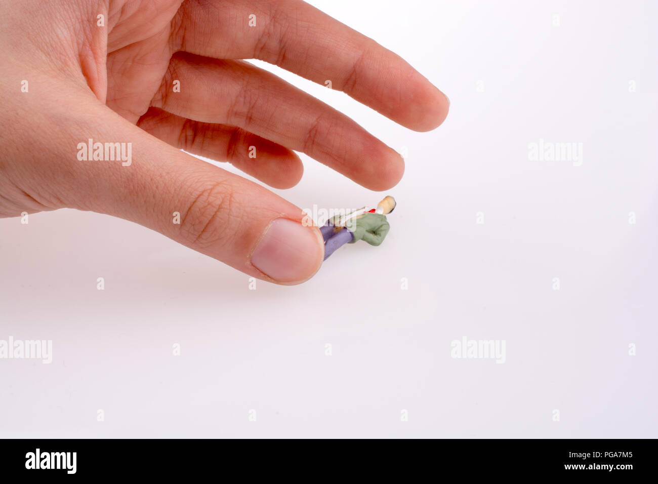 Hand holding a figure on a white background Stock Photo - Alamy