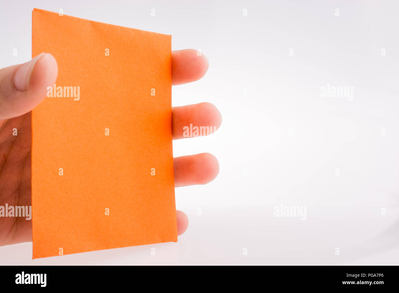 Hand holding orange color rectangular paper on a white background Stock ...