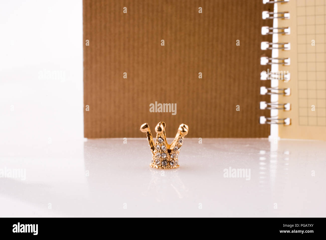 Crown with a notebook on a white background Stock Photo - Alamy