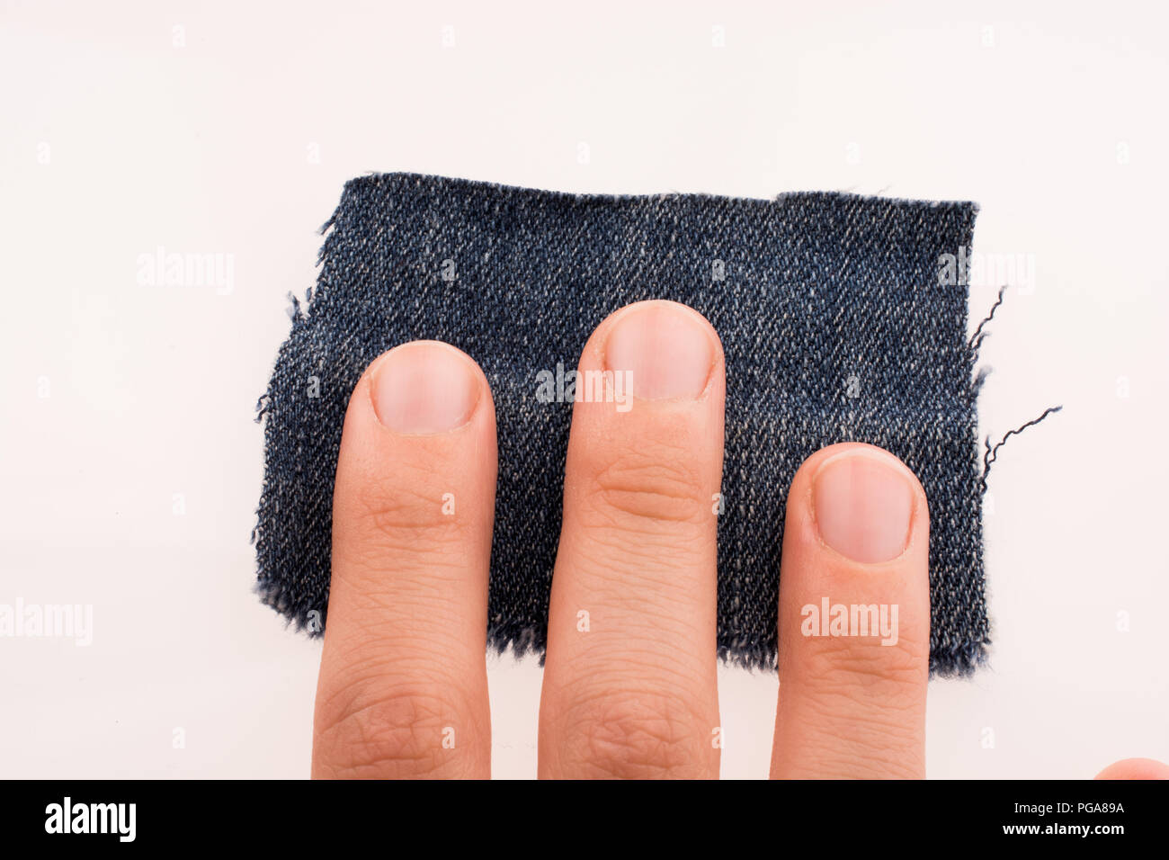 Hand holding a denim fabric piece on white background Stock Photo - Alamy